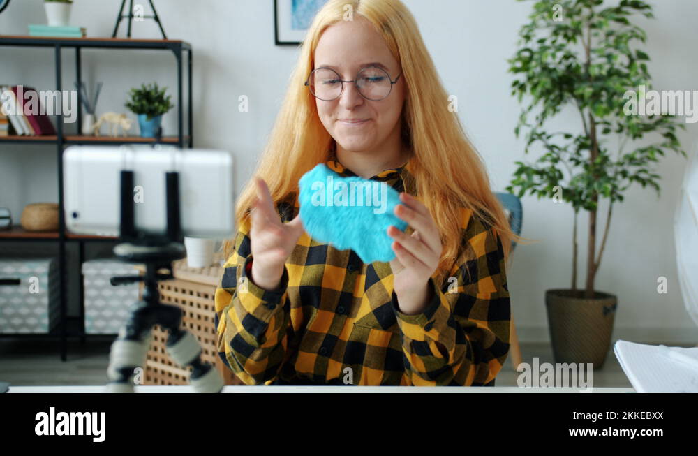 Teenage vlogger recording video with play dough using smartphone camera ...