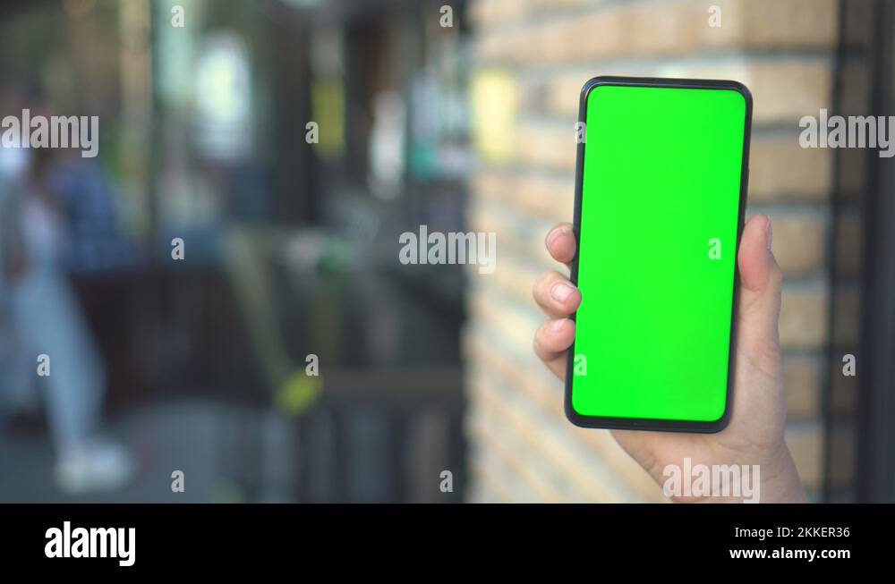 Close up hands woman holding phone with vertical green screen on busy street Stock Video Footage ...