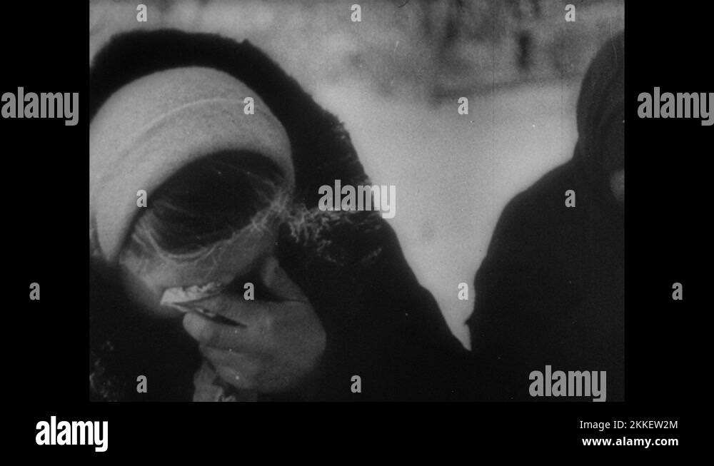 1940s: People look down on dead bodies. Woman cries. Frozen dead bodies ...