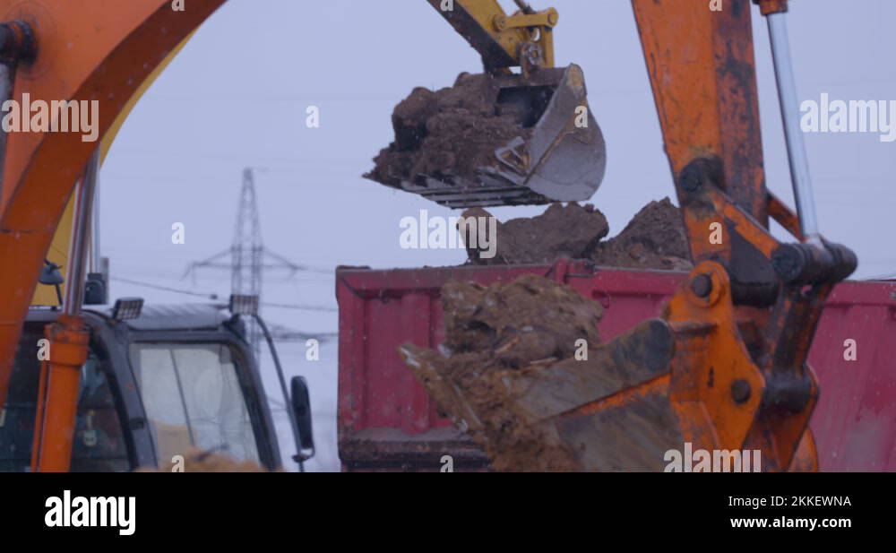 Excavation at a construction site, excavators loads the trucks with ...