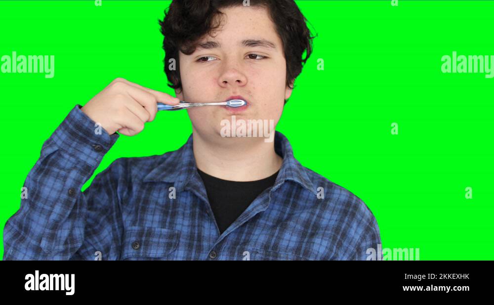 Teenage boy brushing his teeth at green screen background 1 Stock Video ...