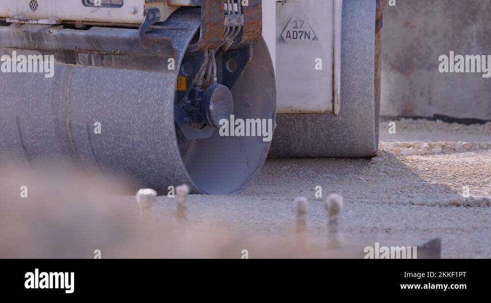 Construction roller compact the gravel base to further pave the area ...