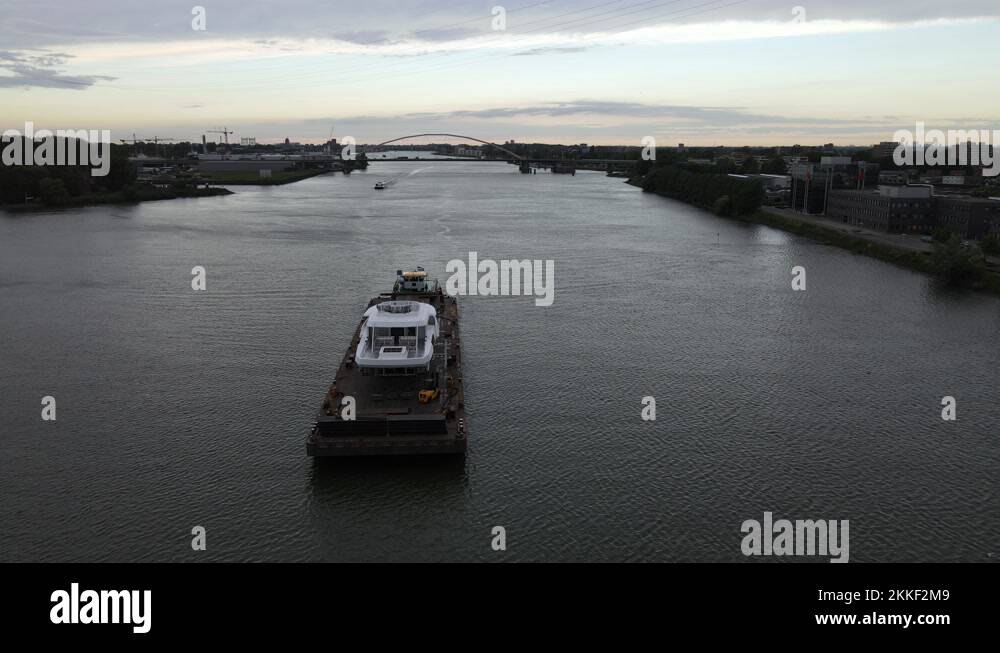 Pusher pushing a pontoon with the white accomodation of a luxury yacht ...