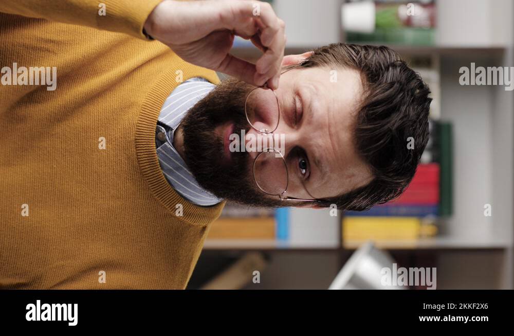 Man winks. Vertical video of positive smiling bearded man with glasses ...