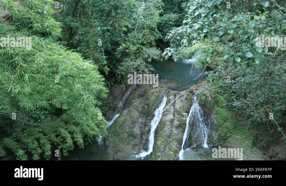 Descending aerial of a waterfall in the jungle of the Caribbean island ...