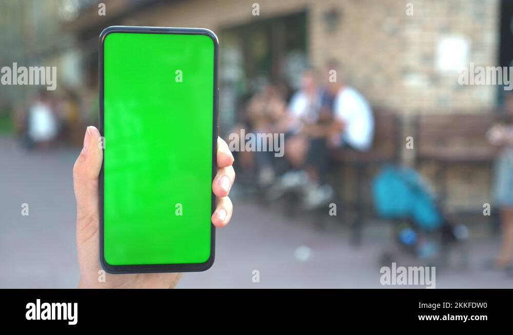 Close up hands woman holding phone with vertical green screen on busy street Stock Video Footage ...