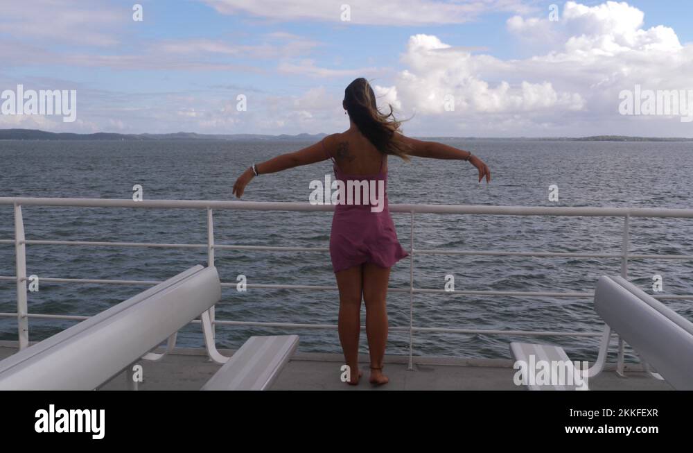 Back View Of A Sexy Female Tourist On A Cruising Ferry Raises Hands In ...