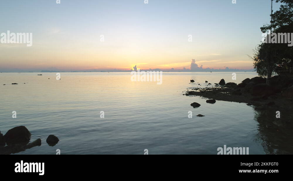 Thailand sunset aerial: silhouette woman rise up hands on ocean stony ...