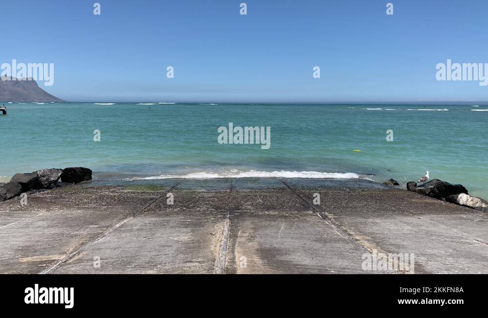 Strand fishing boat concrete slipway into the blue ocean Stock Video Footage - Alamy