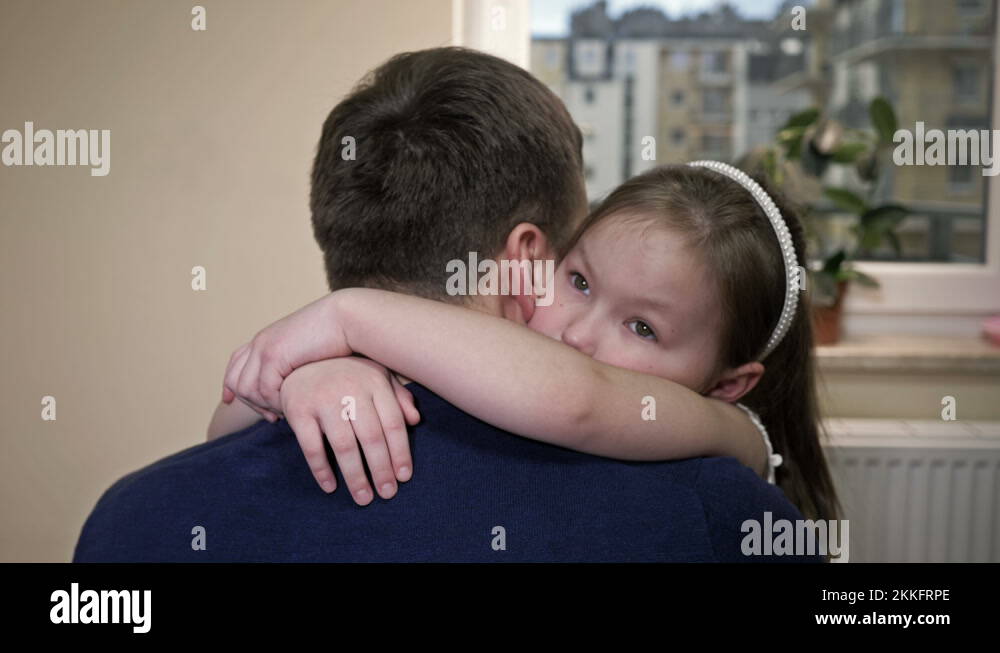 A 6-7 year old girl gently hugs her dad. The joy of being a father ...