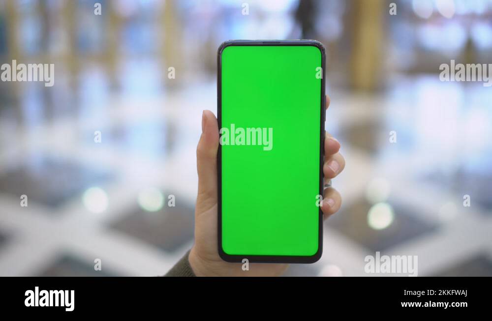 Handless csmera: Back view of female holding chroma key green screen ...