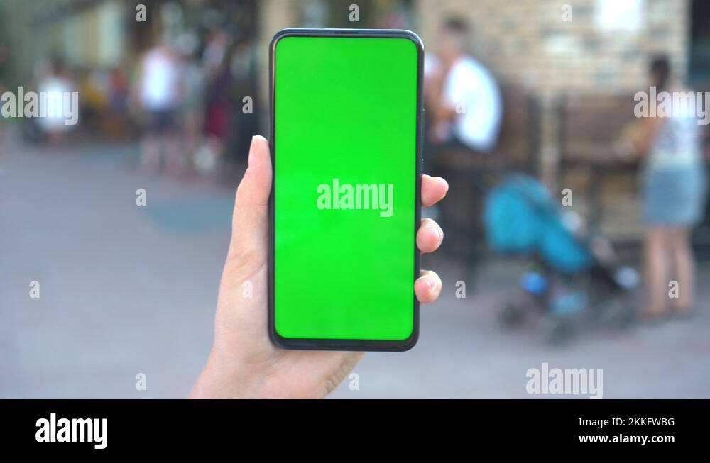 Close up hands woman holding phone with vertical green screen on busy street Stock Video Footage ...