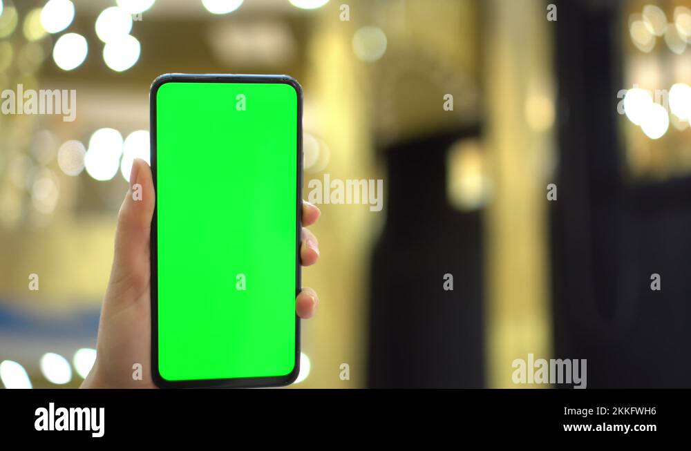 Handless csmera: Back view of female holding chroma key green screen ...