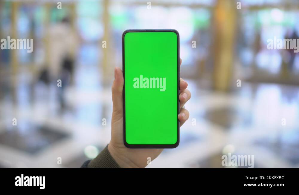 Handless csmera: Back view of female holding chroma key green screen ...