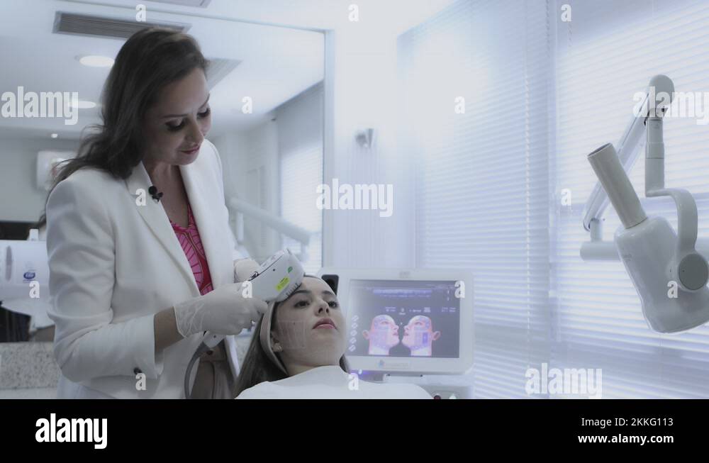 Beautician uses a skin treatment device to perform a facial procedure ...