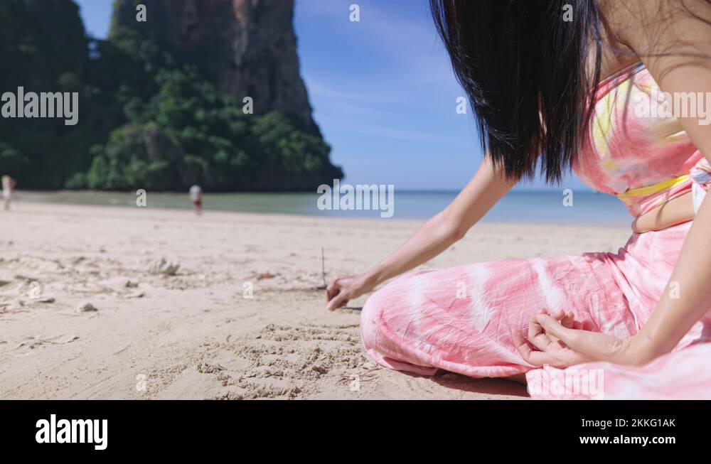 asian woman use wood stick writing words playing sand on summer beach ...