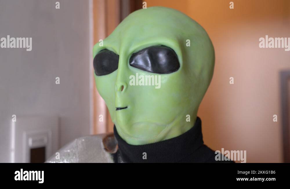 Alien nods head approvingly and enters the room, close up. Man in alien ...