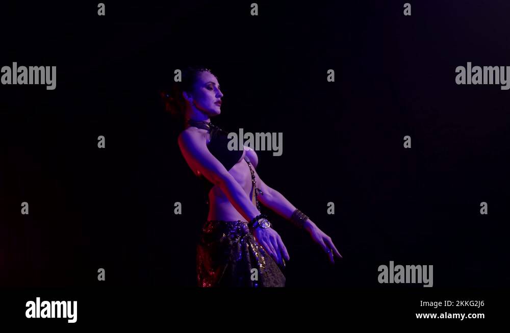 Sexy Woman Who Dances Oriental Belly Dance On A Black Background She