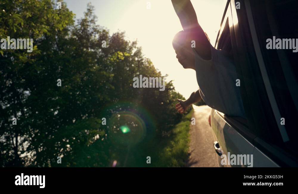 Happy child stretched out his hand from the car window. Happy family ...