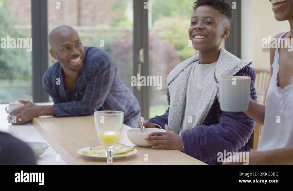 Young Girl Making Her Brother and Parents Laugh During Breakfast Stock ...
