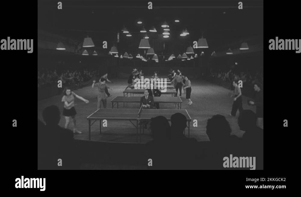 1940s: Ping-pong tables lined up in stadium. People play ping-pong in a ...