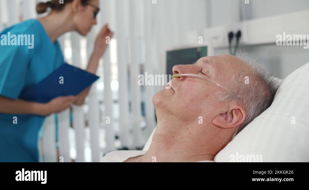 Close up of aged patient with nasal breathing tube sleeping in hospital ...