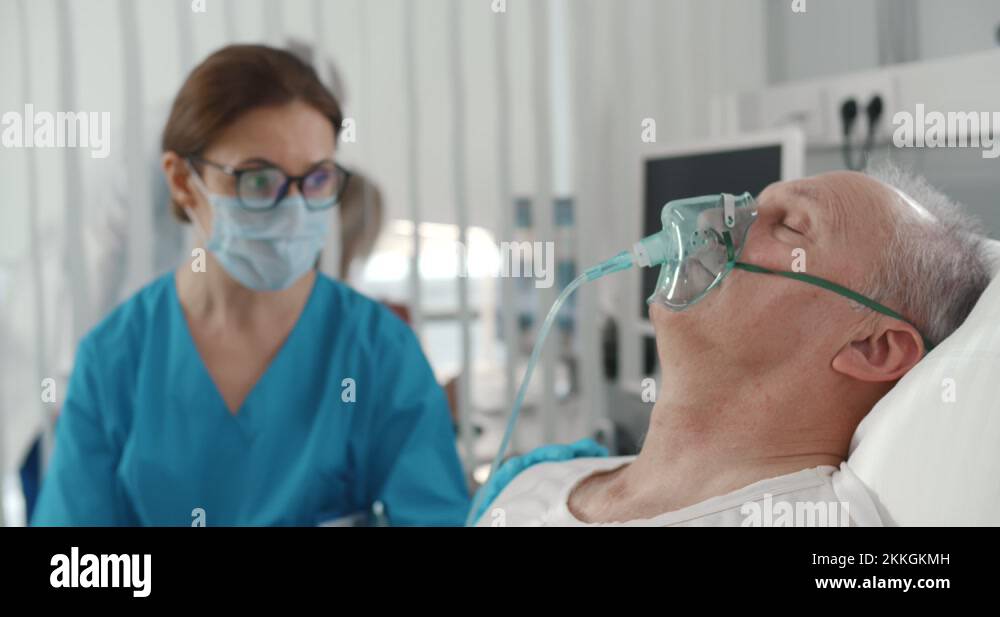 Doctor checking senior man with oxygen mask breathing hard because of ...