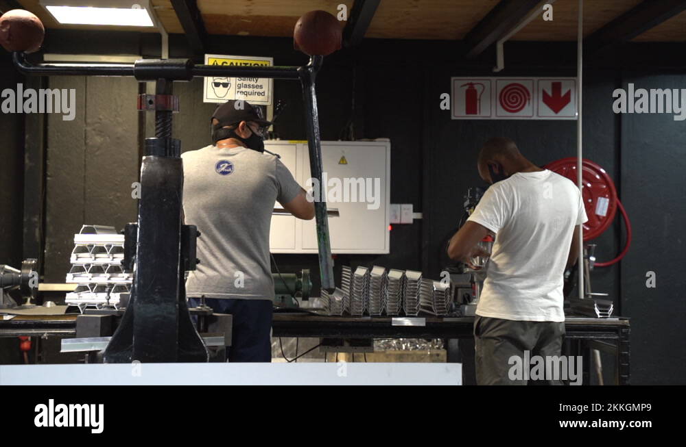 White male looking over to a African American man working in a shop ...