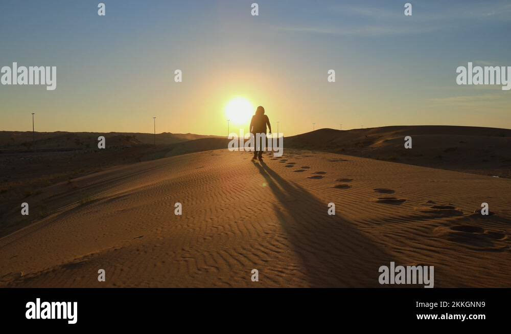 Silhouette: A man walks alone in the Arabian Desert of the United Arab ...