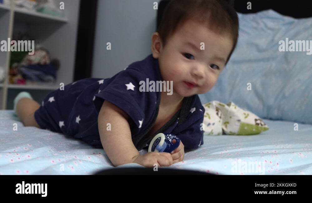 portrait of 8 month Asian Chinese baby boy looks and move around ...