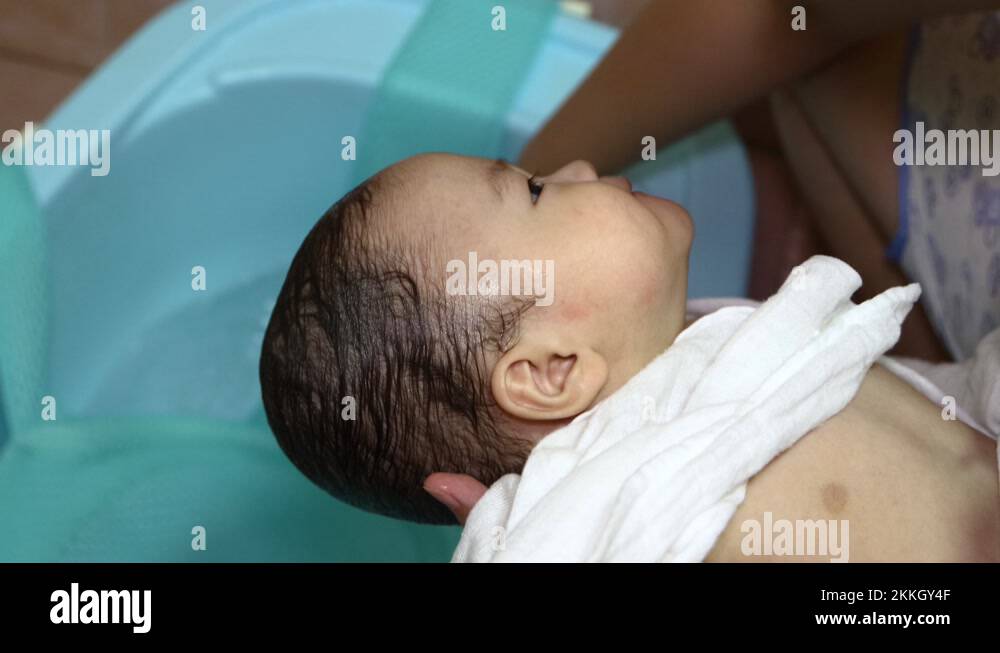 A Chinese Asian mother wipe face of adorable baby using clean ...