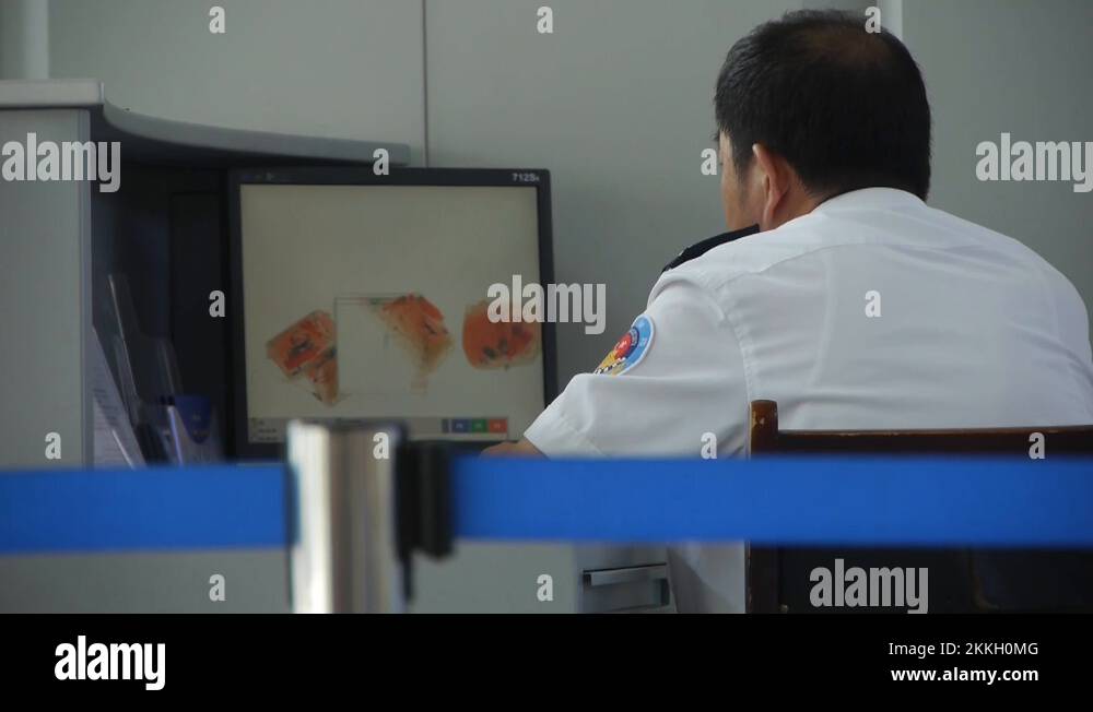 Men using electronic scanner to check items at airport & railway ...