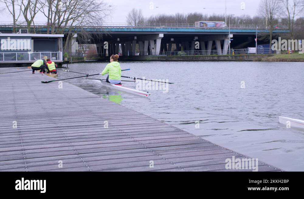 Rowers preparing to starting training and pushing off the jetty ready ...
