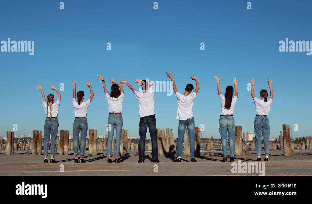 Young guys and girls waving their hands in sync Stock Video Footage - Alamy