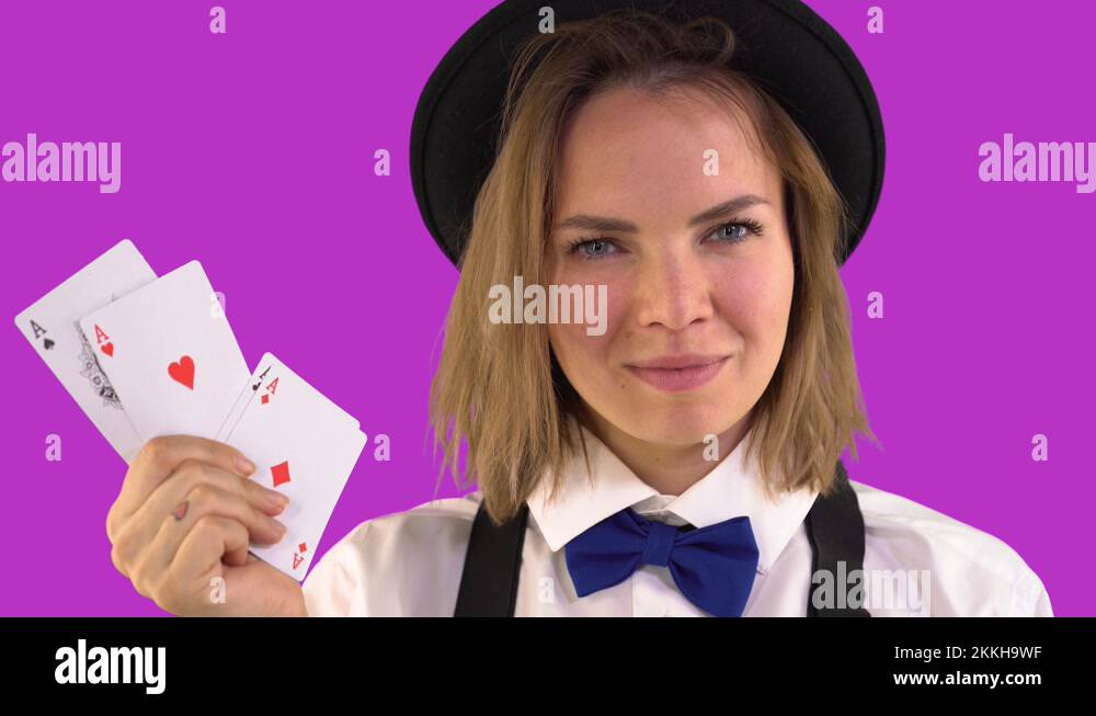 Croupier girl in a white shirt and hat and bow-tie shows playing cards ...
