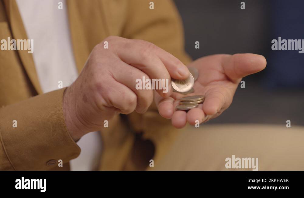 The old man counting the coins in one hand and putting them one after ...
