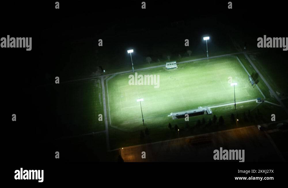 Flying over an empty, lighted soccer field at night in an airplane ...