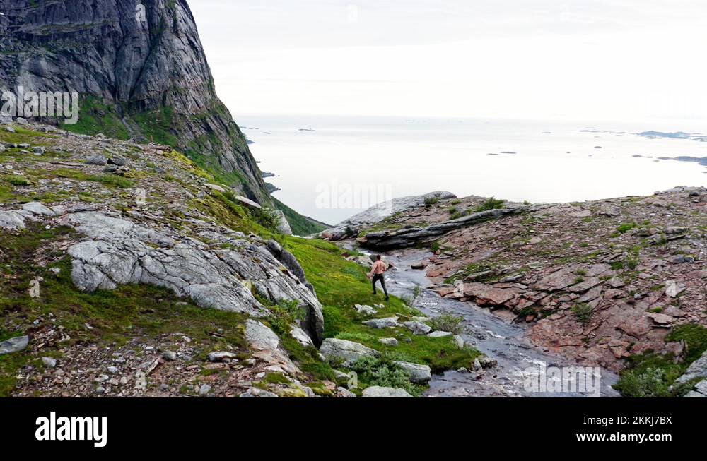 Shirtless Man Running On Edge Of River Flowing Through Waterfall With A ...