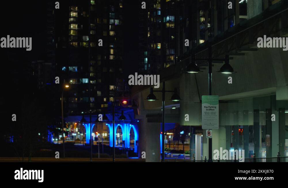 a busy city at night with moving vehicle and a passing train, static ...