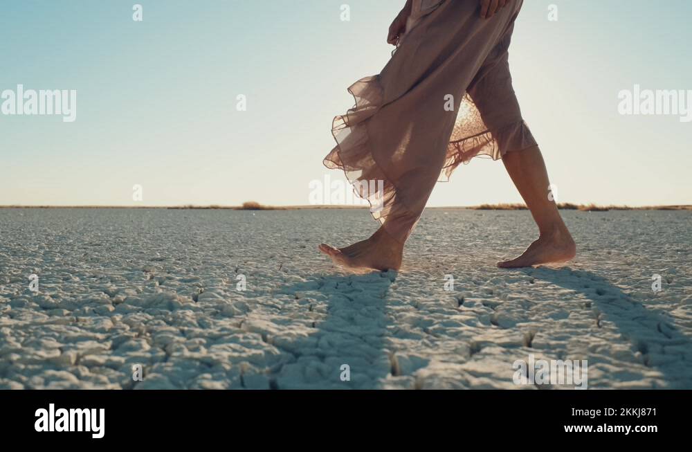 adult woman walking barefoot on bottom of dried lake ,stepping on ...