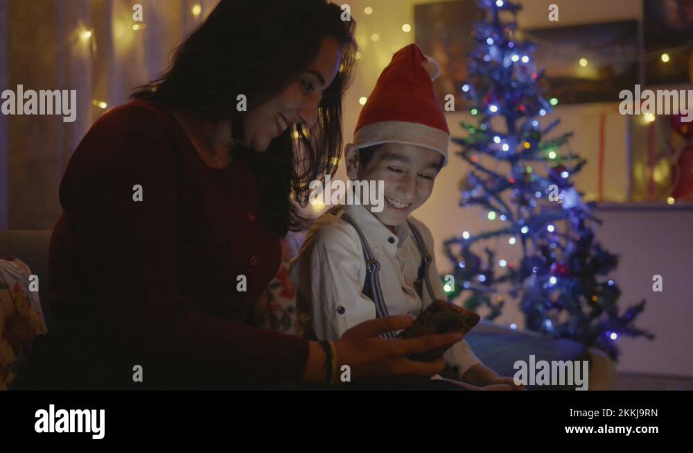 Mother and son are smiling and watching funny video using mobile phone ...