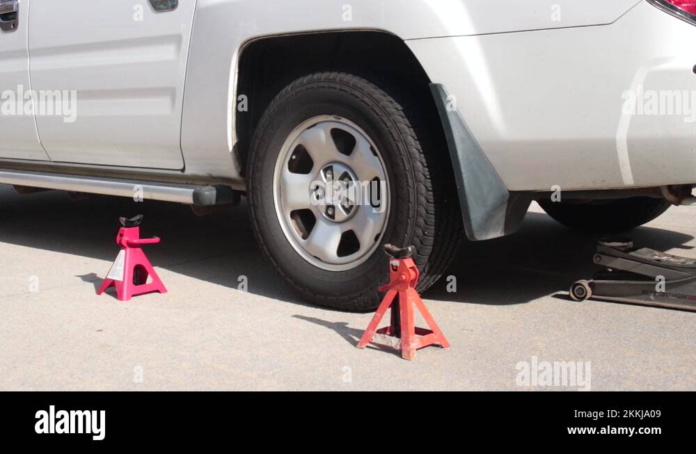 Shade Tree Mechanic Jacking Up Back of a White Truck with Floor Jack ...
