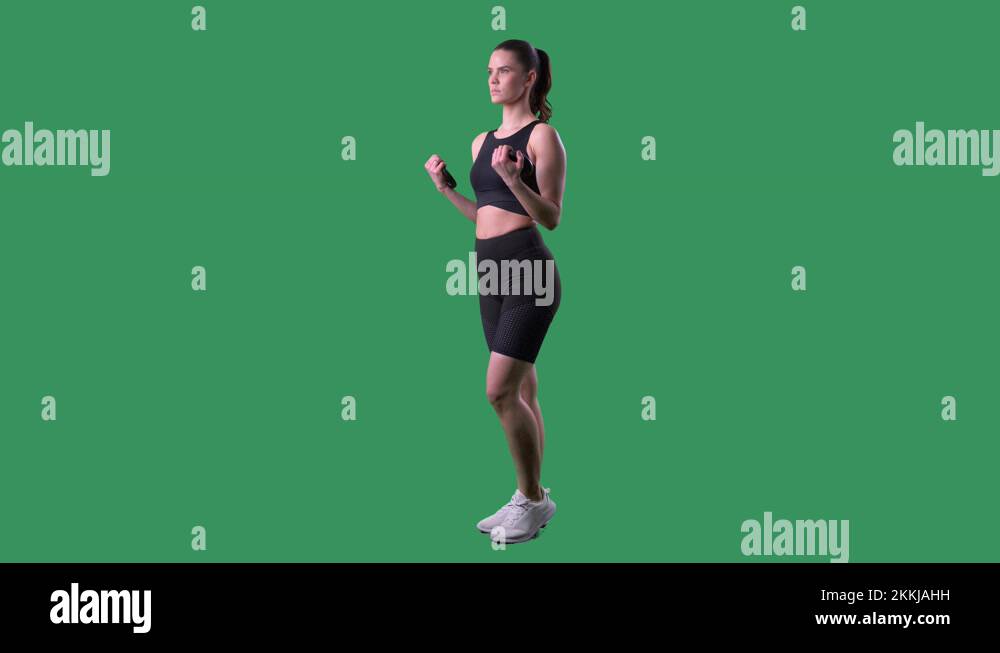 Fit woman doing biceps weight lifting exercises. Full body on green ...