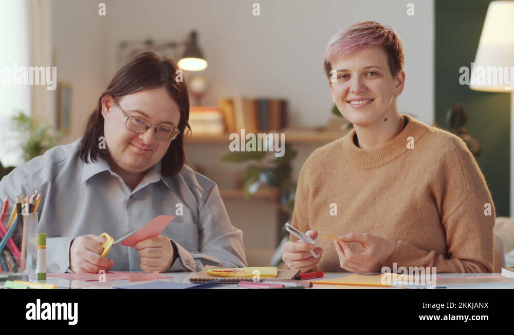 Portrait Of Female Teacher And Man With Down Syndrome At Art Lesson