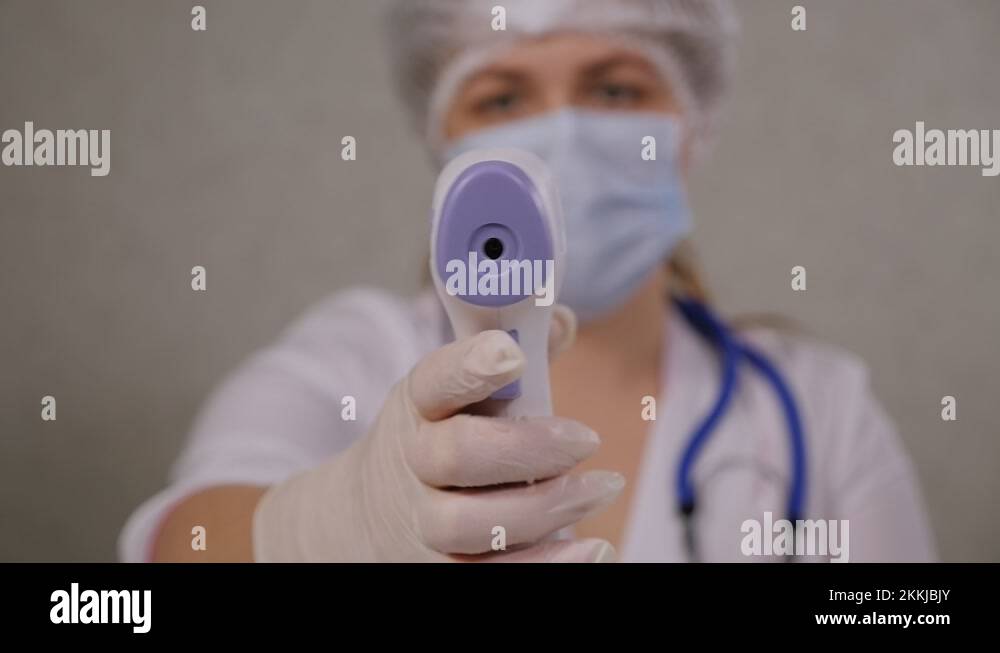 Female doctor is measuring your body temperature with a infrared ...