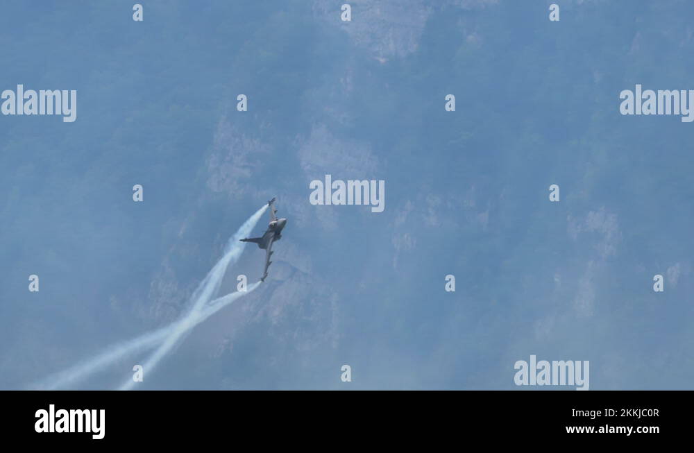 Frontal view of combat jet airplane performing a four points roll in ...