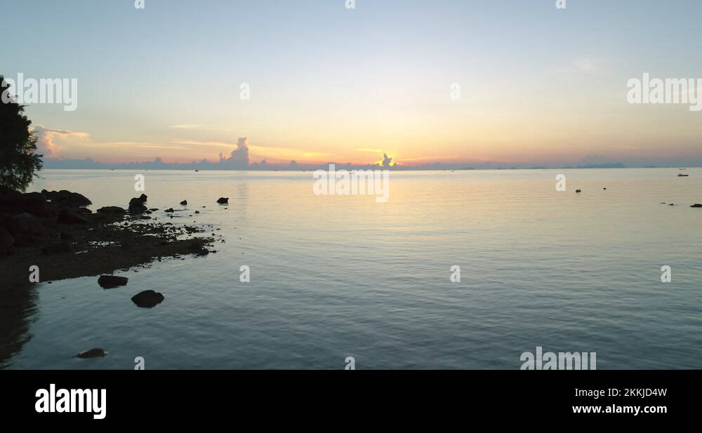 Sunrise Thailand aerial silhouette: woman rise up hands, stays on rocky ...