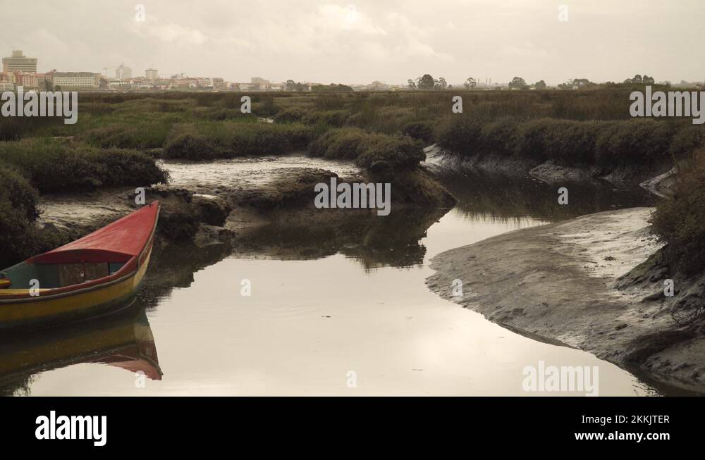 4K old wood fishing boat stranged on the muddy banks of a low tide ...