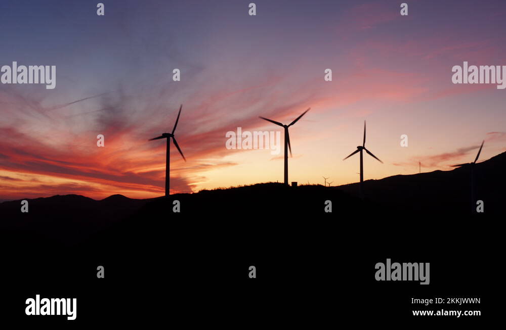 Aerial tilt down view of spinning wind turbine farm during epic ...