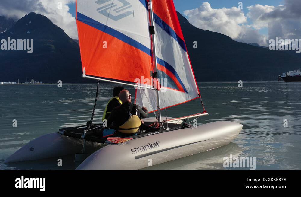 Father and son enjoy the sun while out on their inflatable sailing raft ...
